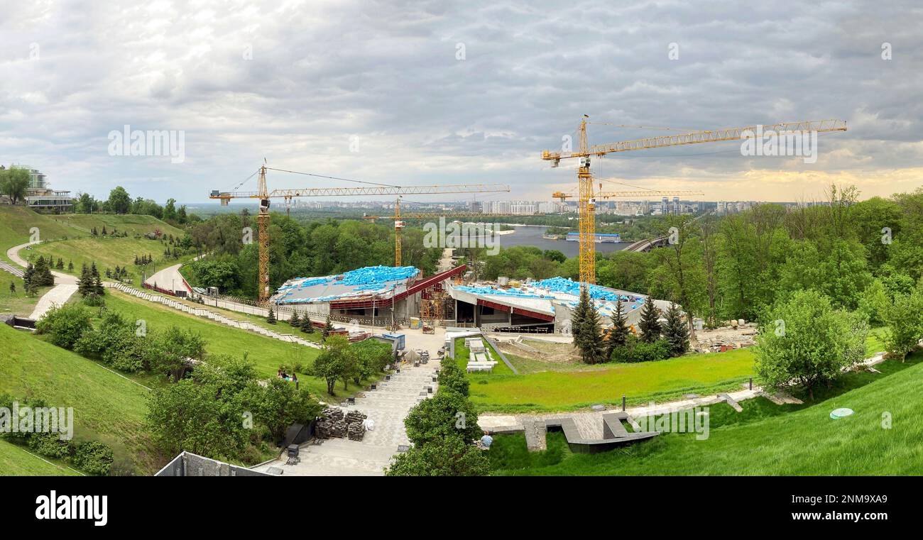 Construction site, three tall tower cranes and blue building materials ...