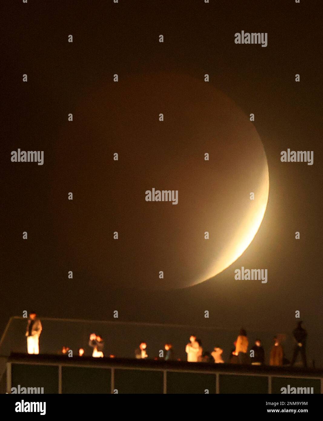 A photo shows a partial lunar eclipse seen in Shibuya, Tokyo on Nov. 19 ...