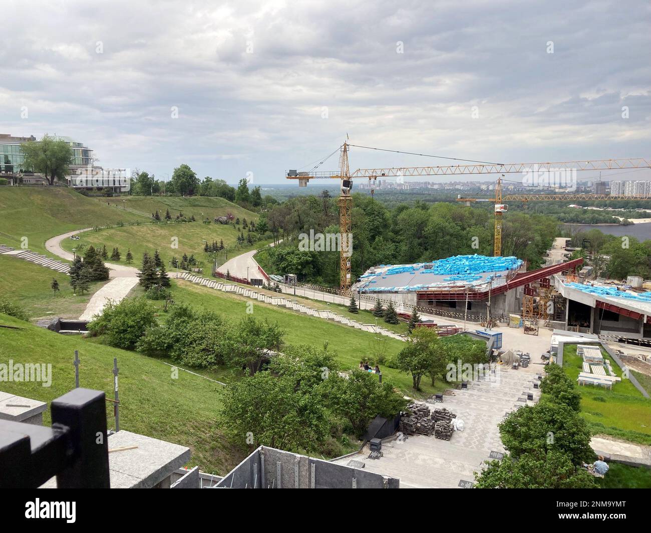 Construction site, three tall tower cranes and blue building materials ...
