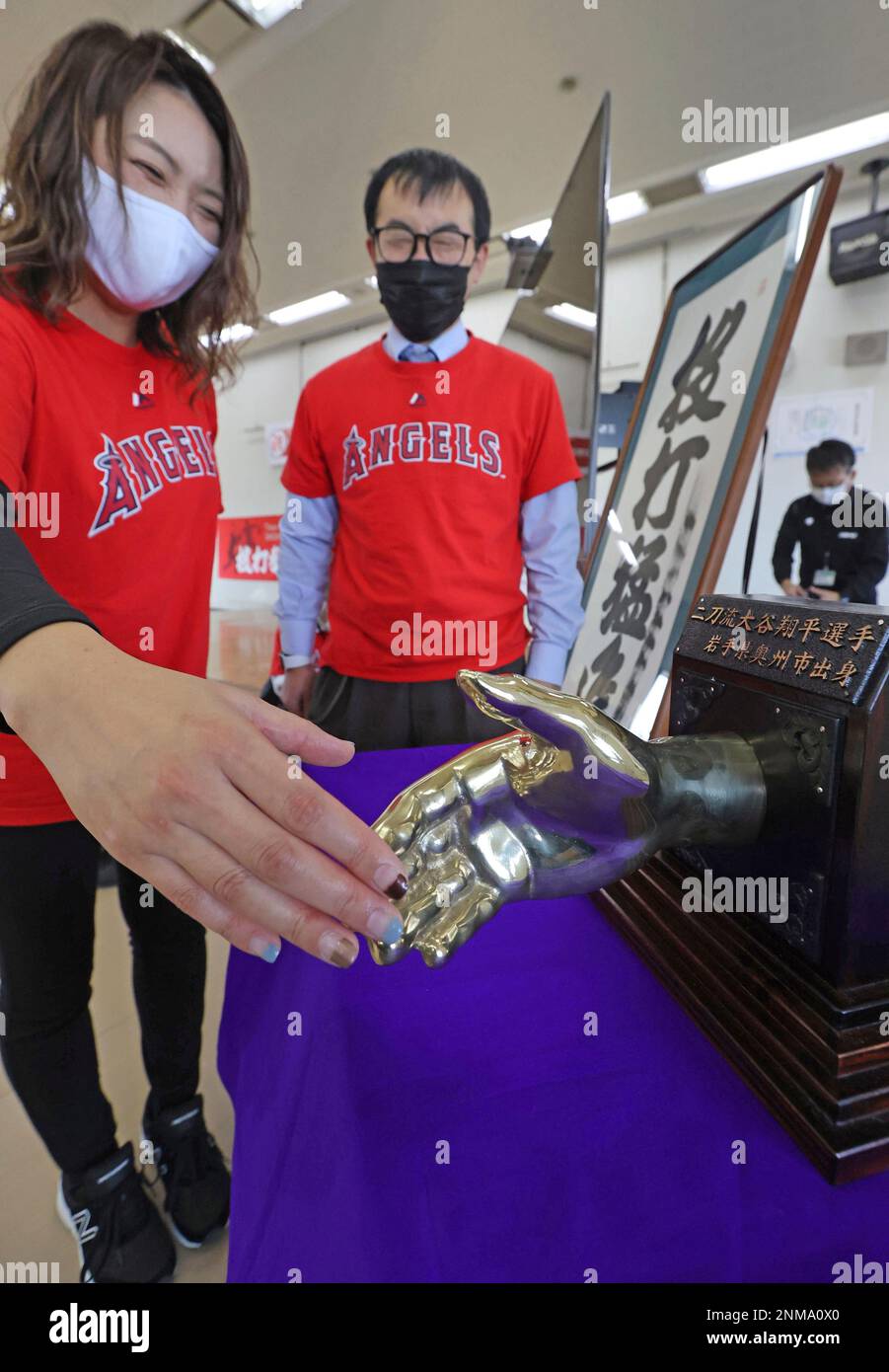 The staffs at city hall are pleased while touching a statue for shaking ...