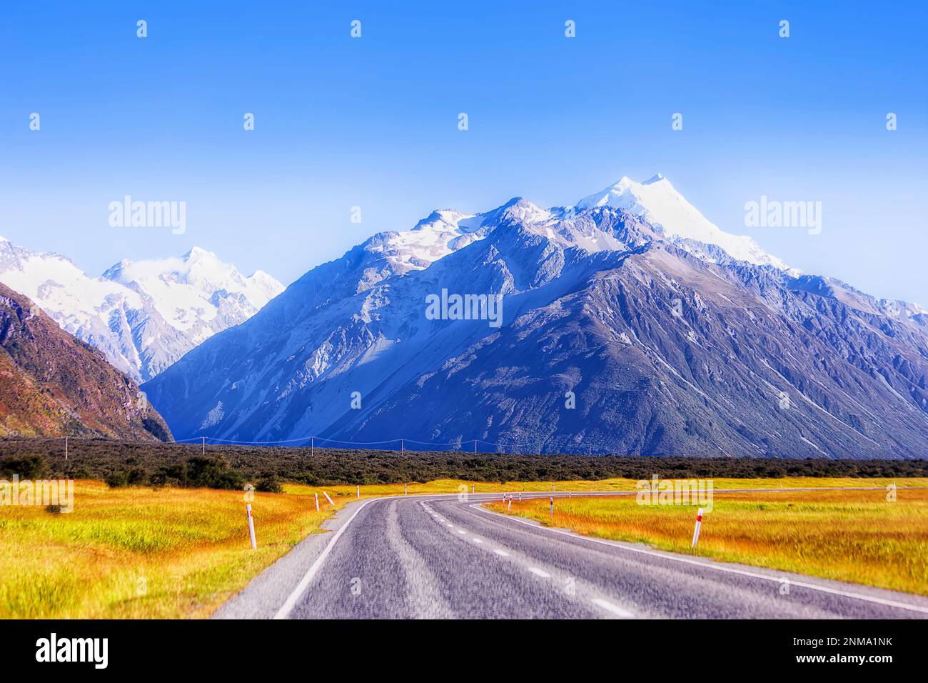 High rocky mountain peaks of Aoraki Mt Cook approached from Highway 80 in New Zealand Stock ...
