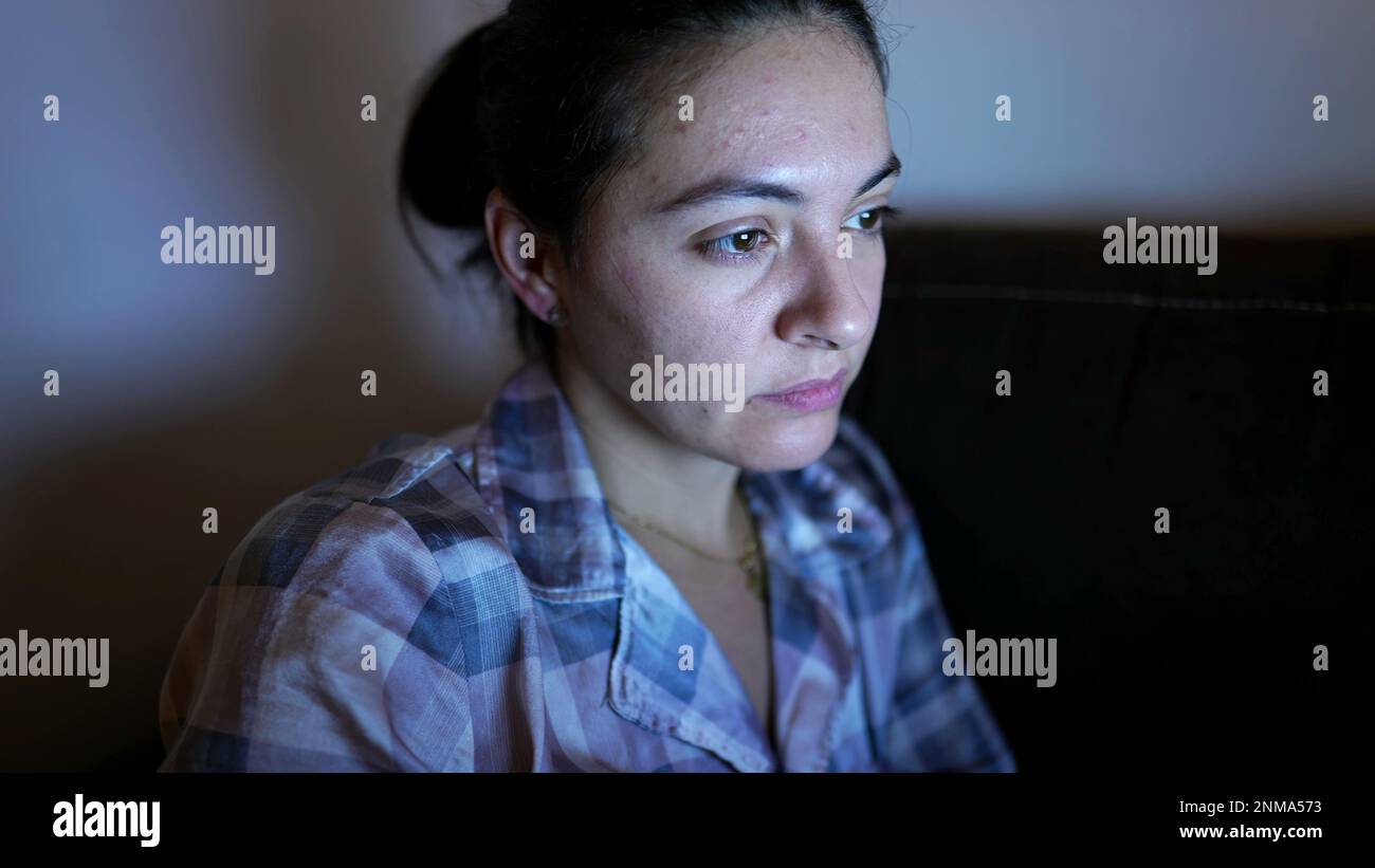 Casual woman in front of computer screen at night browsing internet ...