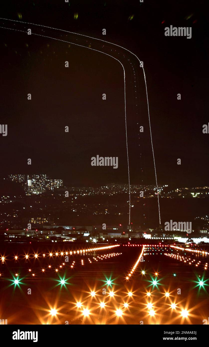 A long exposure photo shows a trail light of airplane taking off from ...