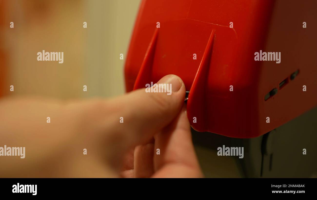 Closeup of Waiting Number Machine. Customer hand pulls a numbered ...
