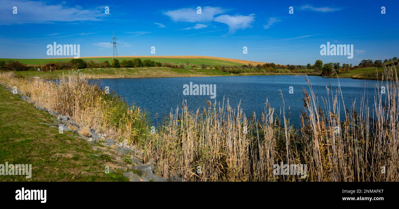 Landscape of Moravian fields with a pond and a beautiful blue sky with ...