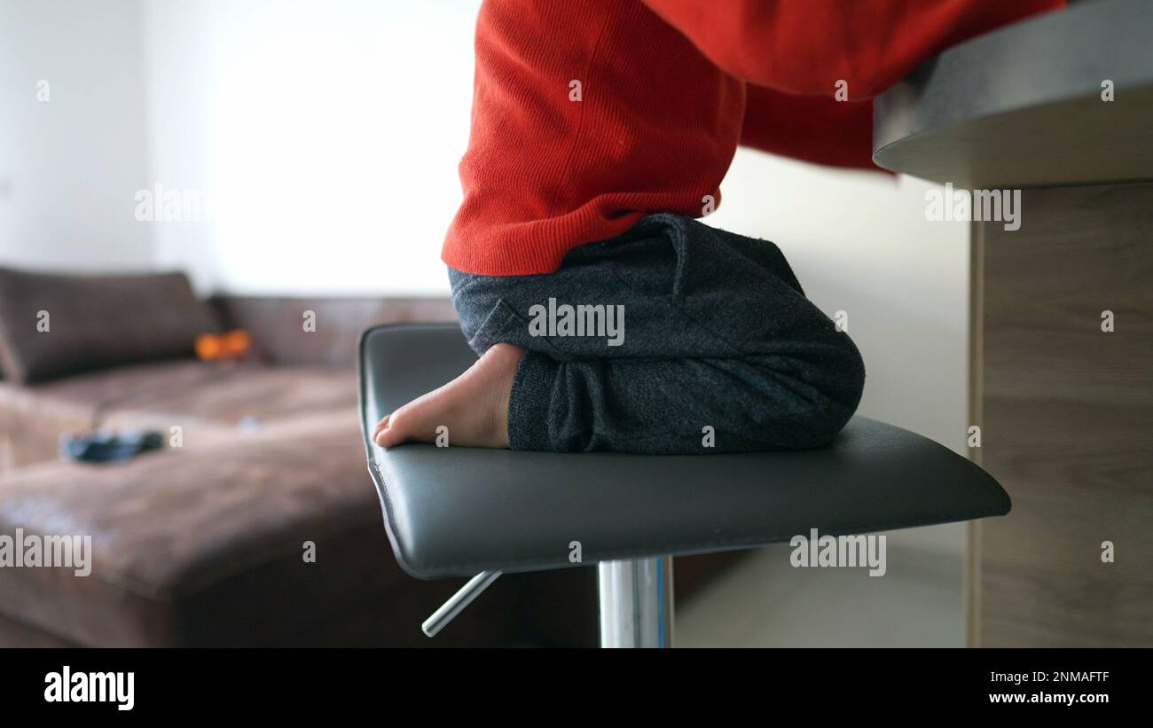 Restless child sitting on kitchen stair stool. One hyper active little ...