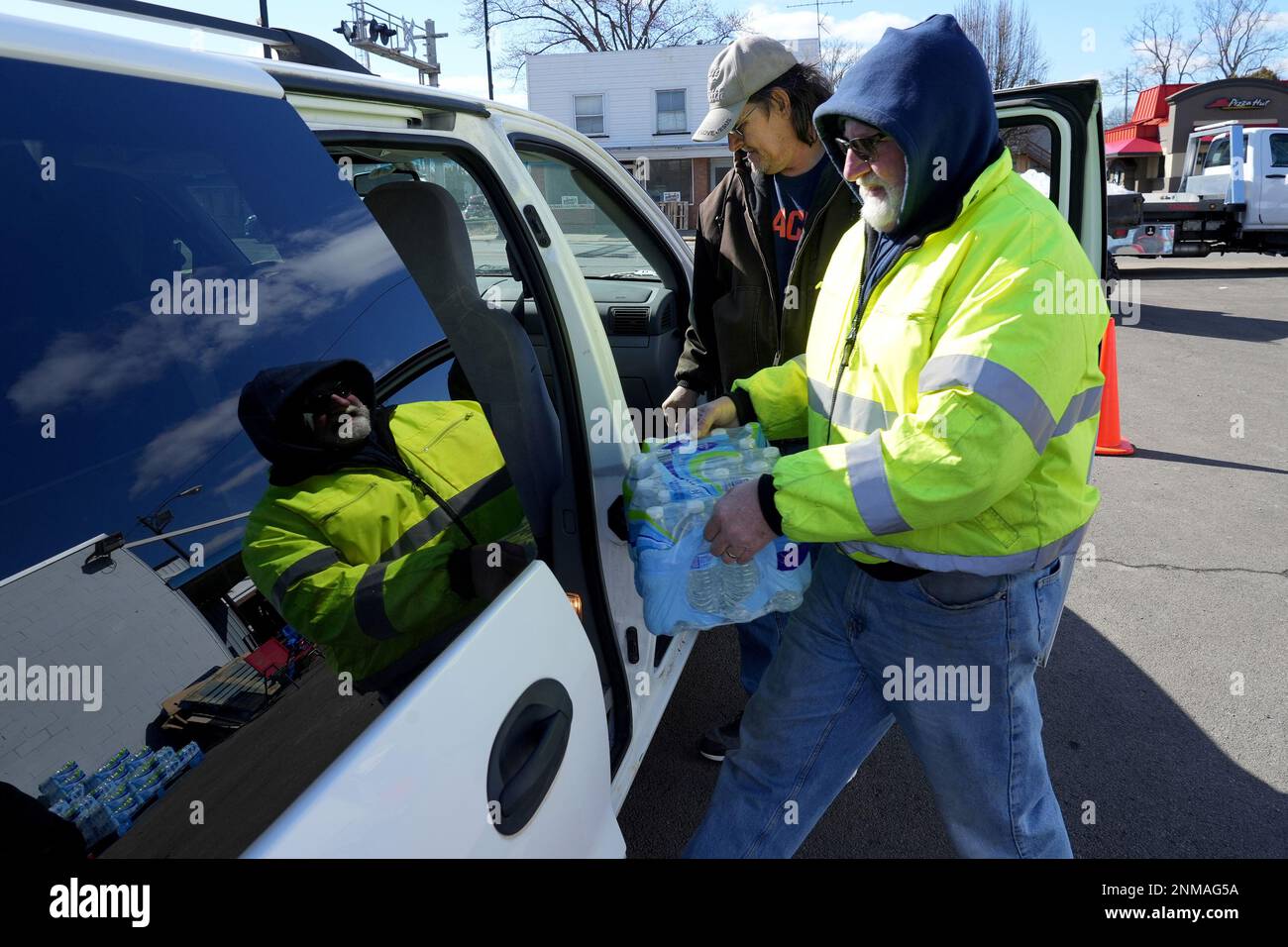 Volunteer Larry Culler helps load water into a car in East Palestine ...