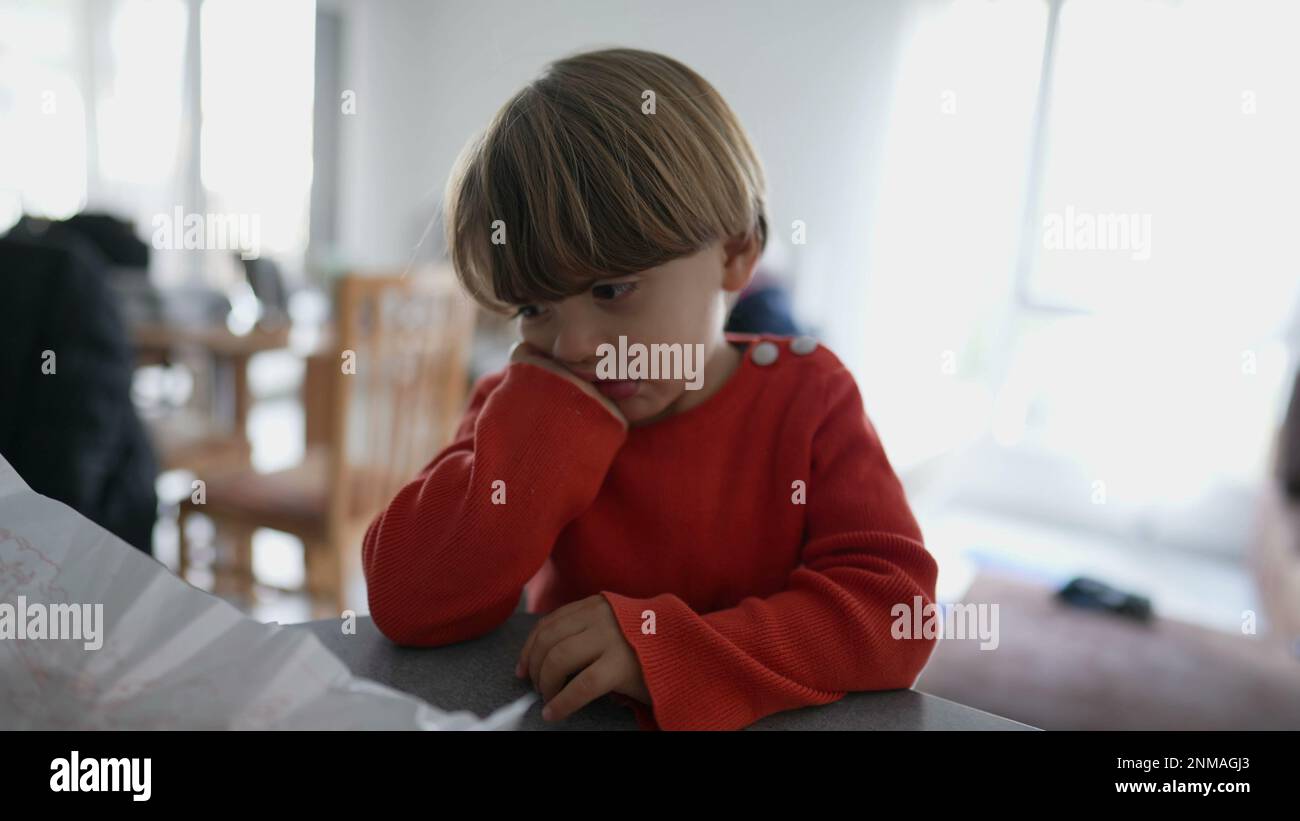 One bored little boy at home with nothing to do. Adorable child hand in ...
