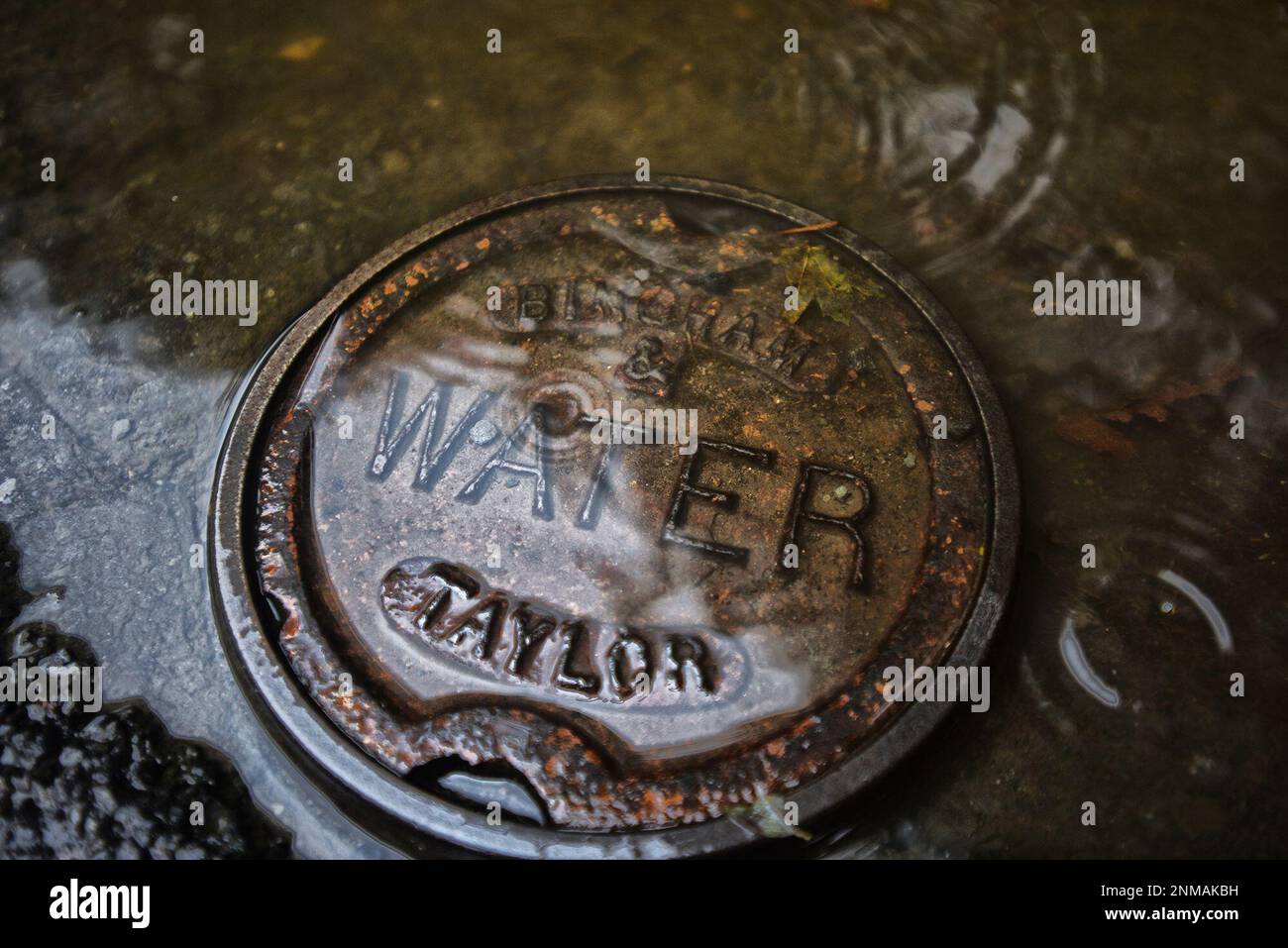 Rain water submerges a water lid on Parry Street in Luzerne, Pa. during ...
