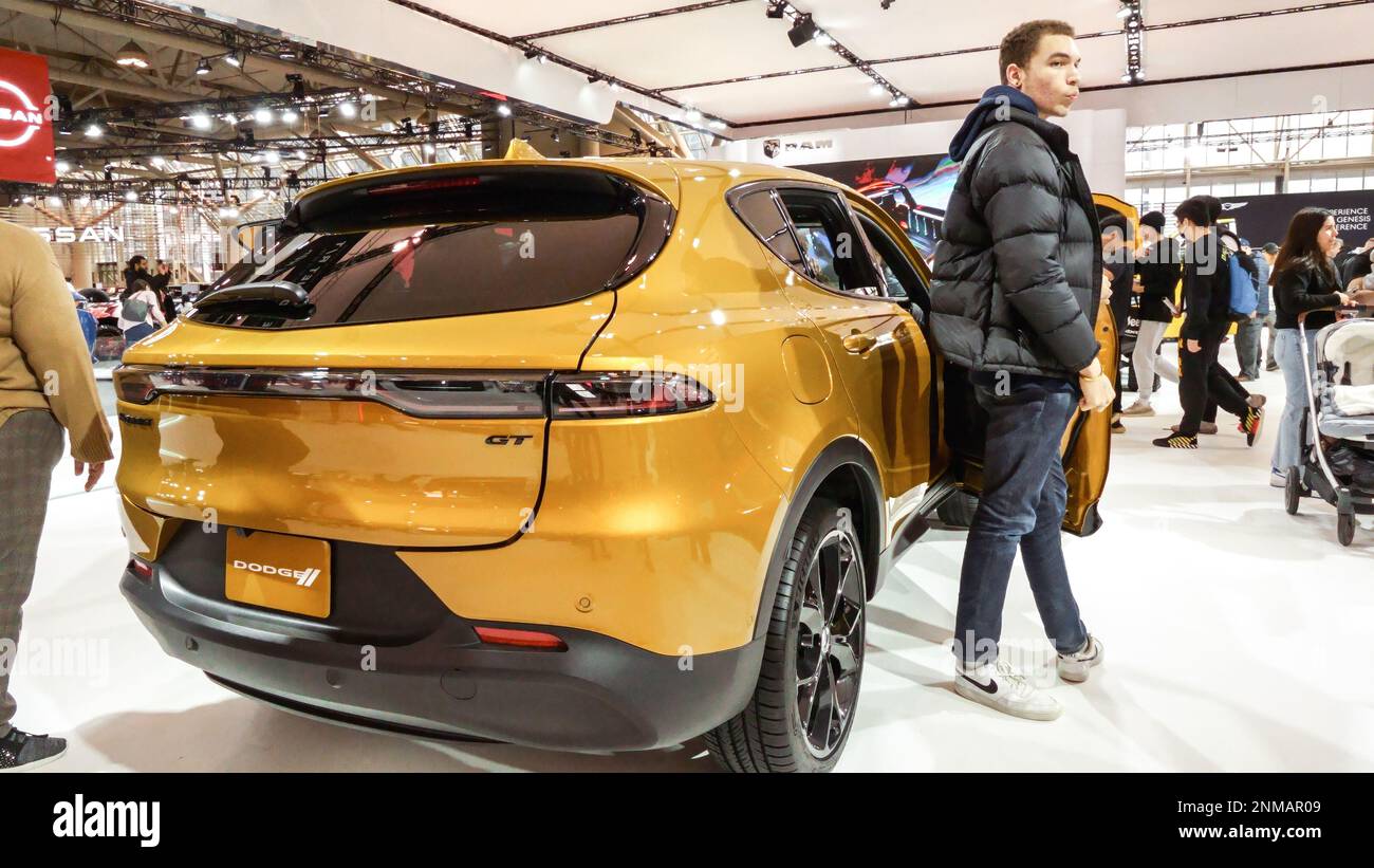 Close up view of yellow dodge GT car on display. Crowds looking at new ...
