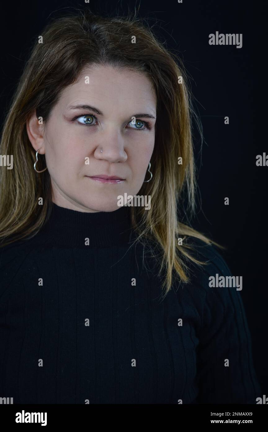portrait of a beautiful blonde woman looking away with a serious and ...