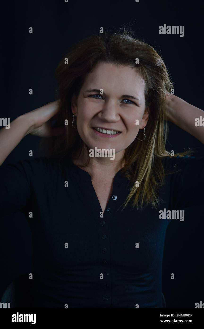portrait of a beautiful blonde woman holding her hair behind her head ...