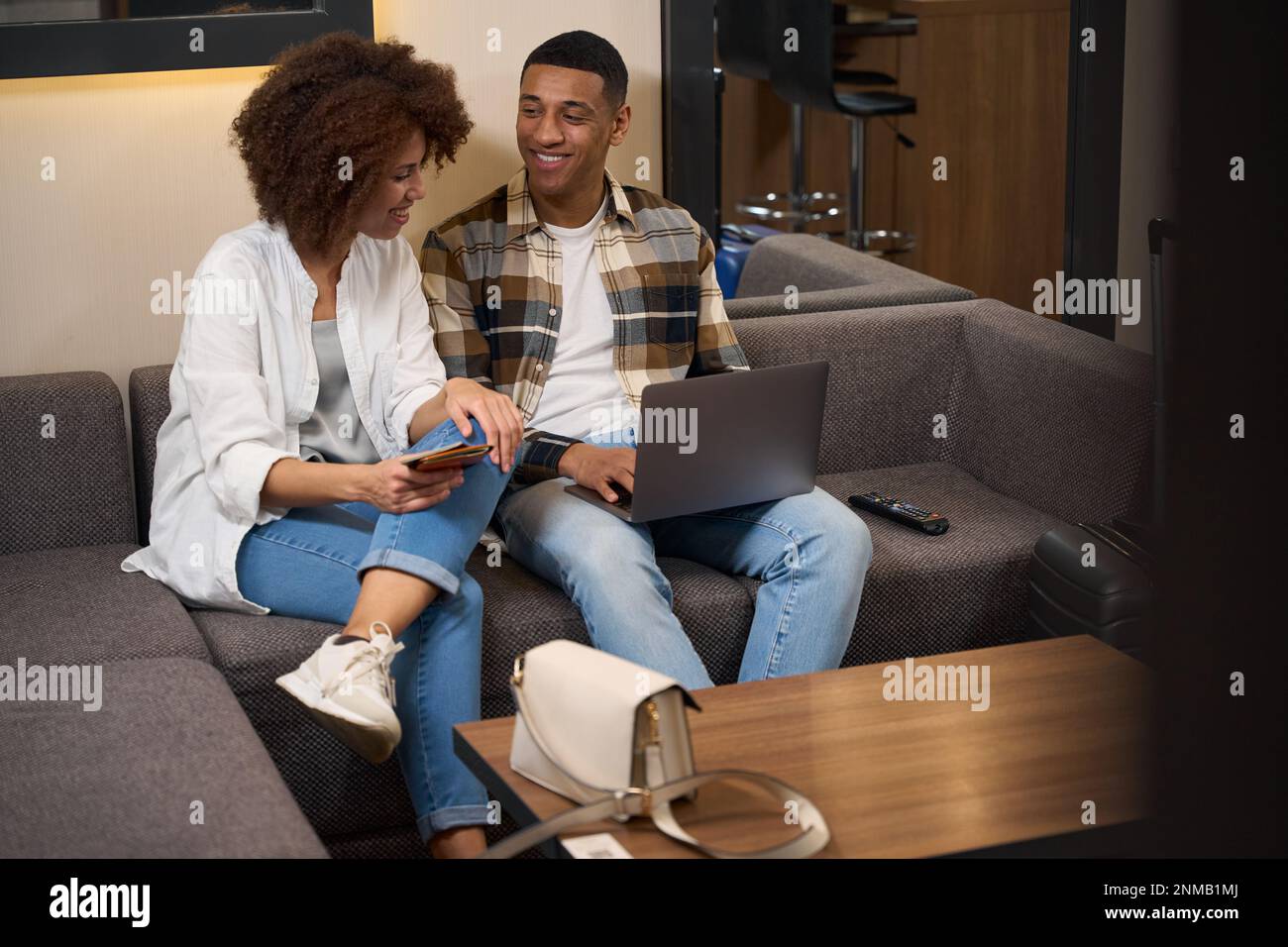 Multiracial husband and wife sit on the couch and chat Stock Photo - Alamy