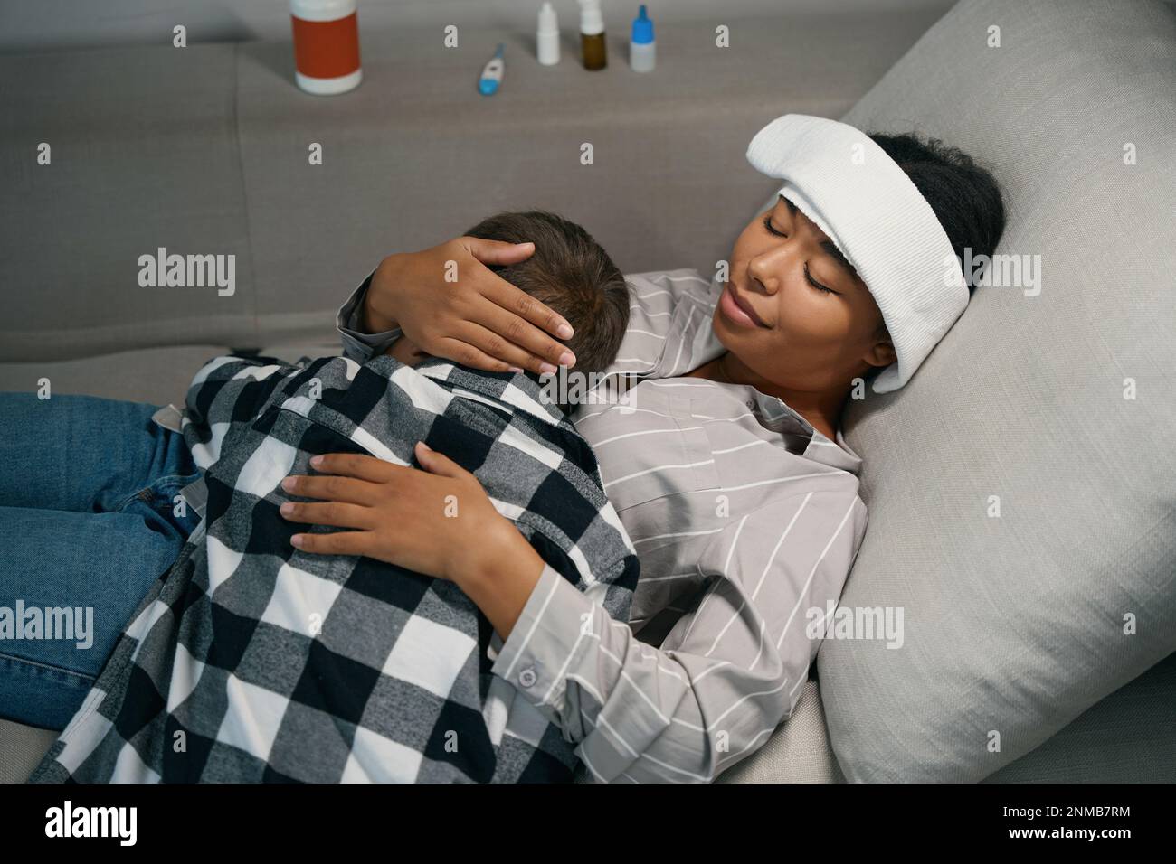 Boy in a plaid shirt hugs his sick mother Stock Photo - Alamy