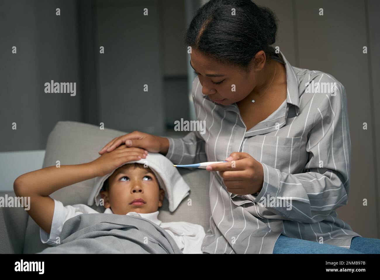 Kind mother takes care of a sick boy Stock Photo - Alamy