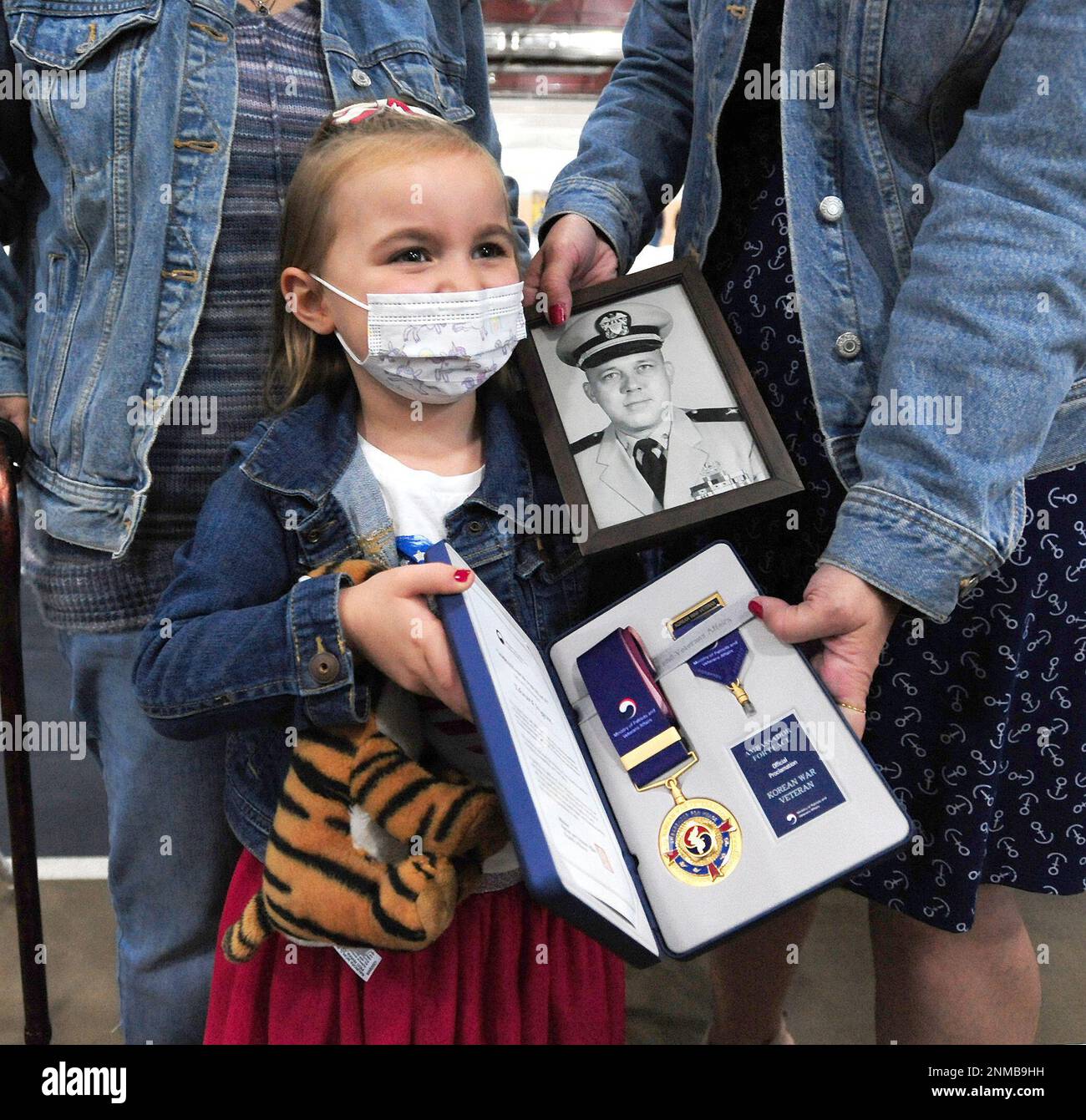 Brenna O'Donnell holds the medal in honor of her great grandfather ...