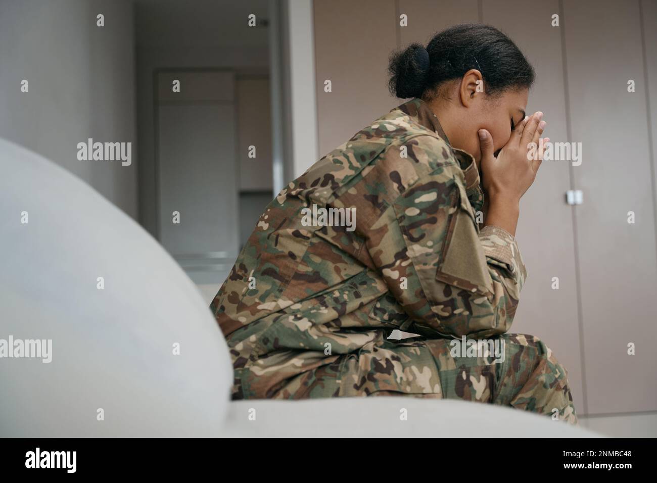 Tired african american female soldier sits alone in bright room Stock ...