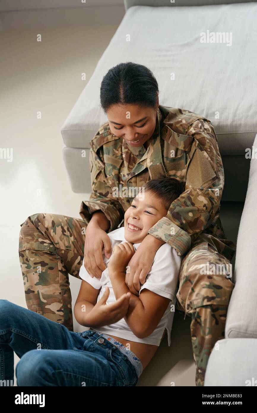 Mother soldier and son play cheerfully in the room Stock Photo - Alamy
