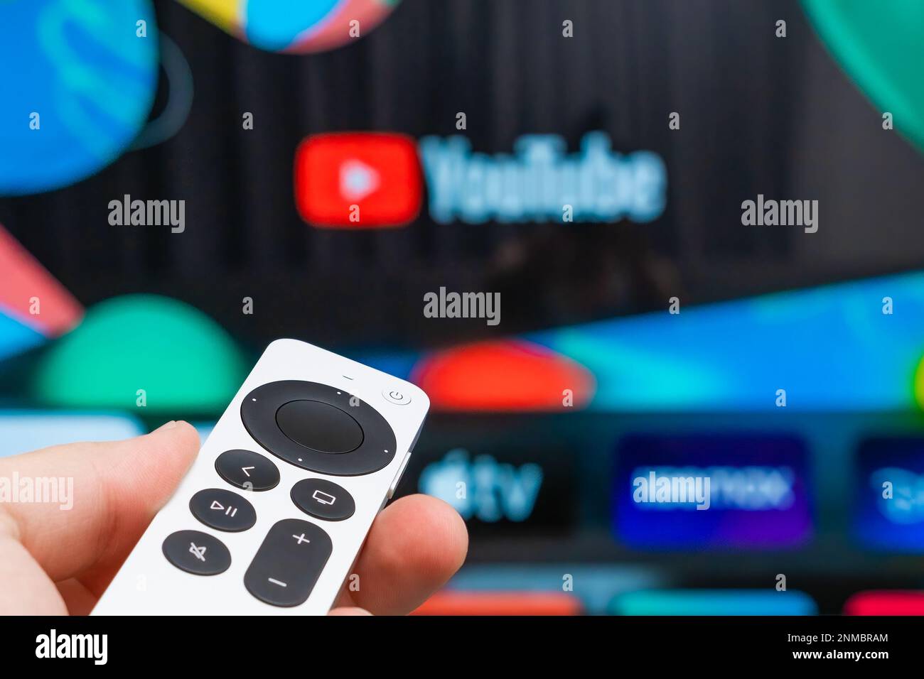Youtube on Apple TV showing on the screen of TV. Man hands switch on ...