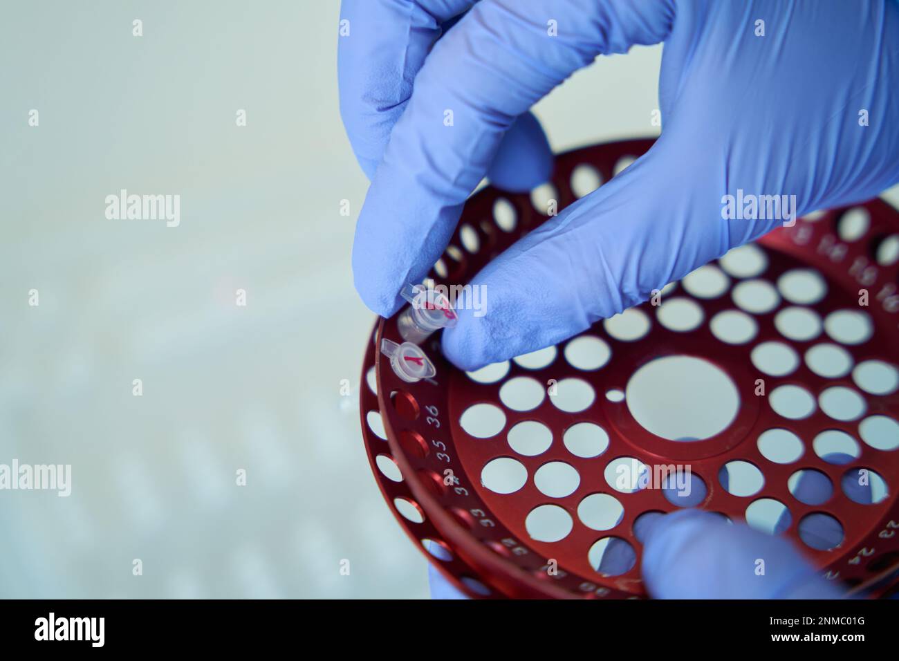 Doctor inserts labeled tubes into cartridge of hematological centrifuge ...