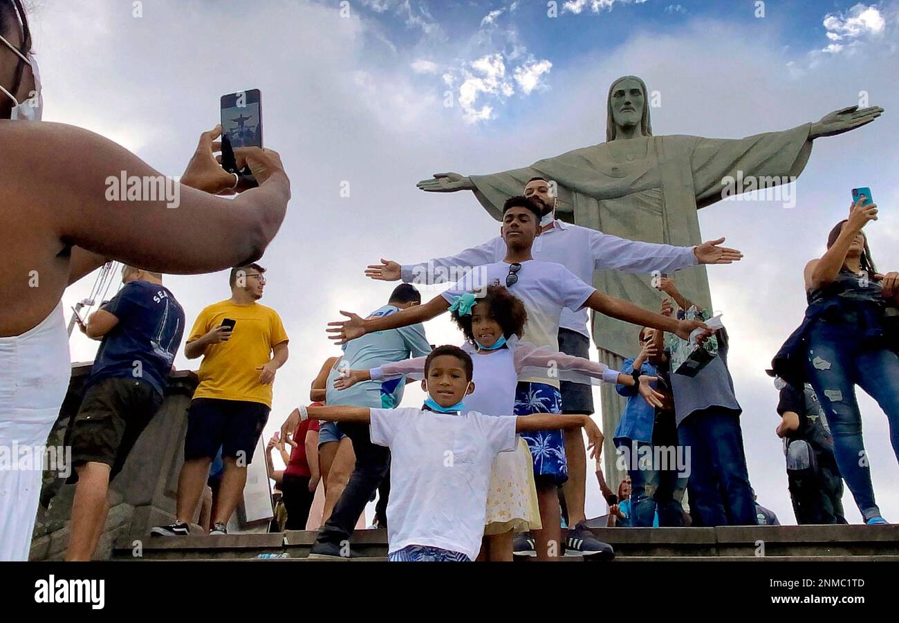 Tourists are seen around the iconic statue of Christ the Redeemer that ...