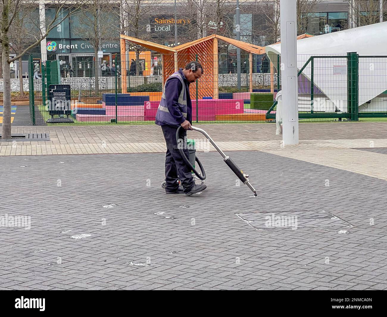 A man cleaning chewing gum from a pavement in Wembley London Stock ...