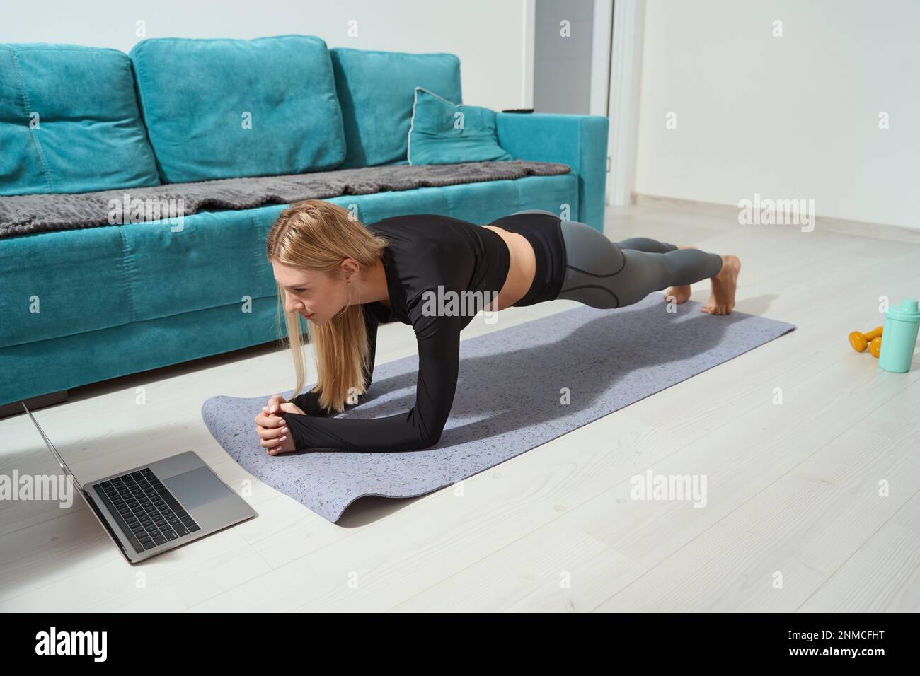 Concentrated fit woman doing isometric core strength exercise on yoga ...