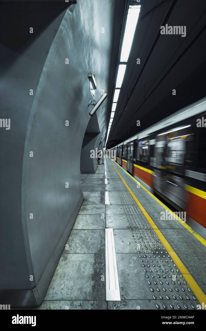 platform of underground station with passing train Stock Photo - Alamy