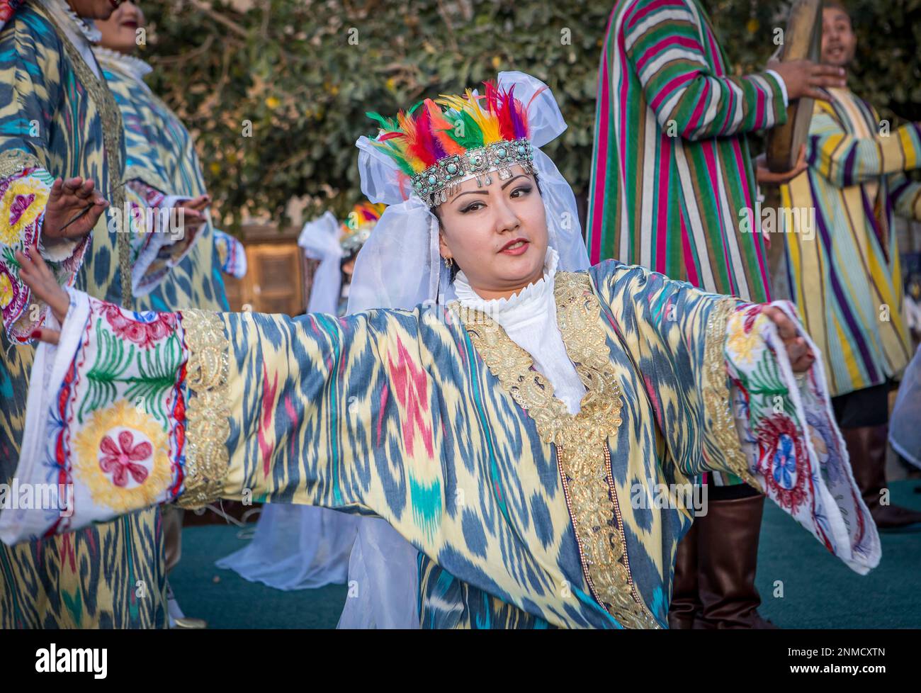 women dancing in traditional dress, in Rukhobod Mausoleum, Samarkand ...