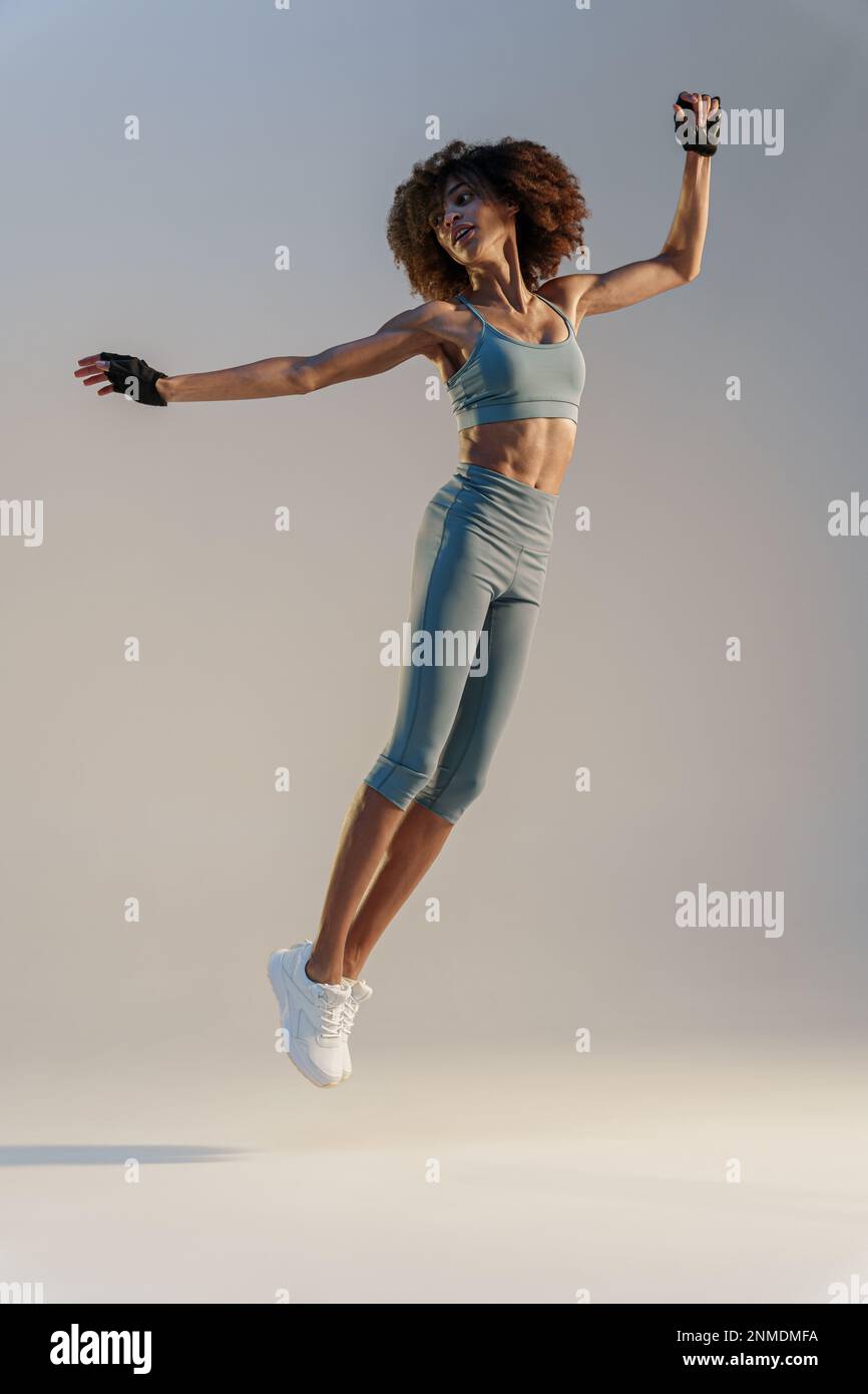 Active sporty woman in sportswear jumping on studio background. Sport ...