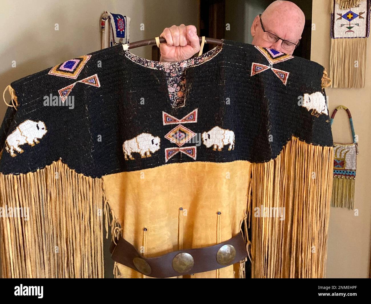 Father Art Faesser shows a beaded elk dress made by Charles and Hazel ...