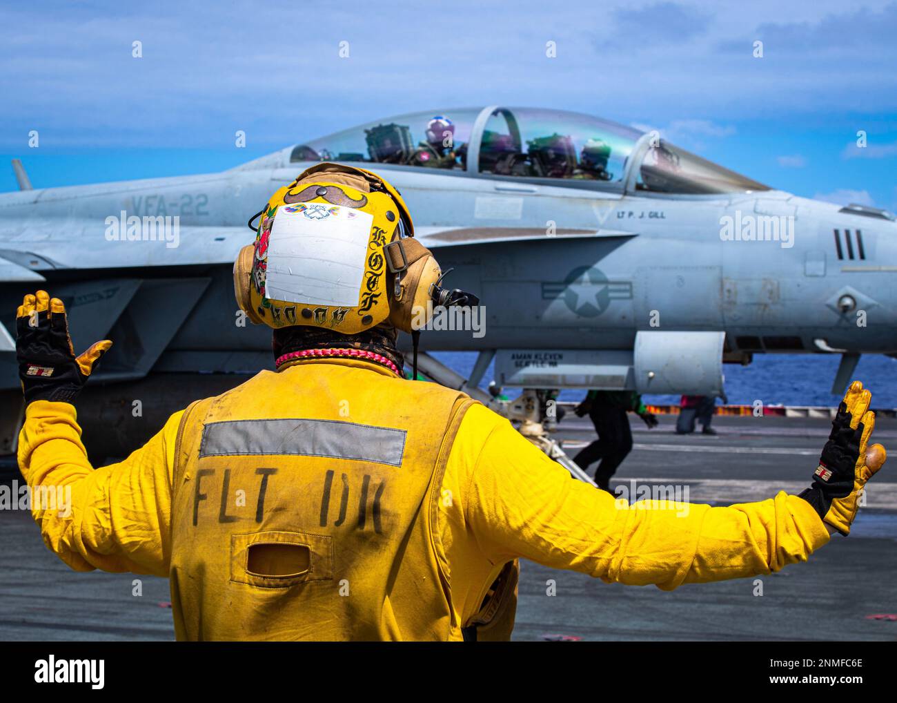 230224-N-MH015-2043 PHILIPPINE SEA (Feb. 24, 2023) A U.S. Navy Sailor directs an F/A-18F Super ...