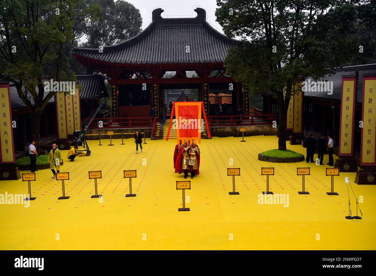 Men dressed in ancient warrior outfits carry a flag in a ceremony ...
