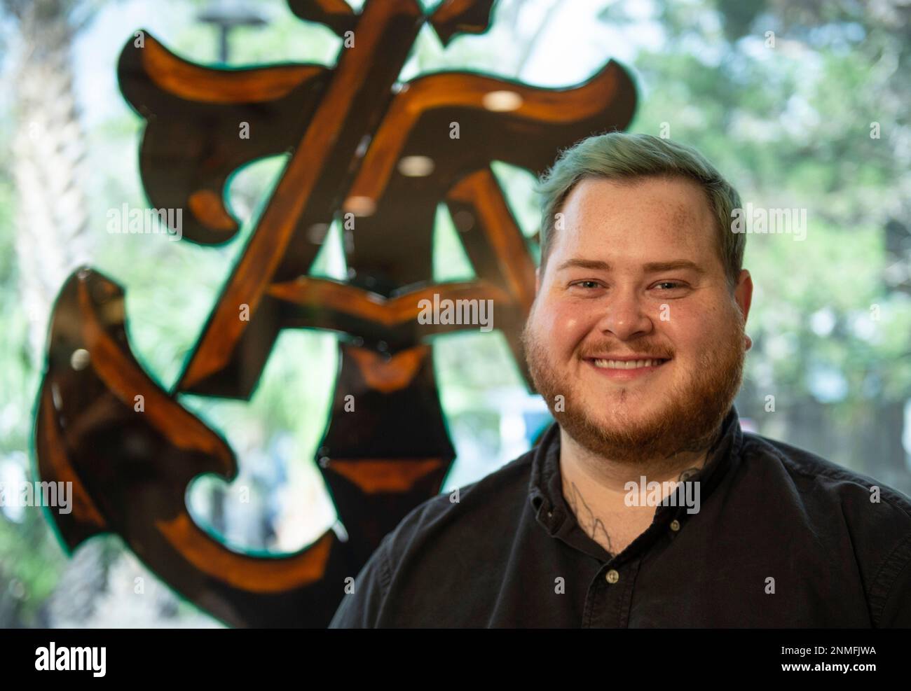 Dylan Sartin, a tattoo artist and illustrator, poses for a portrait at ...