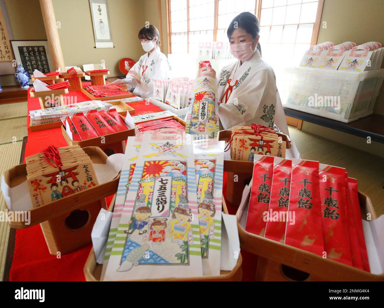 Shrine maidens pack Chitose ame (candy) in bags for Shichi-go-san ...