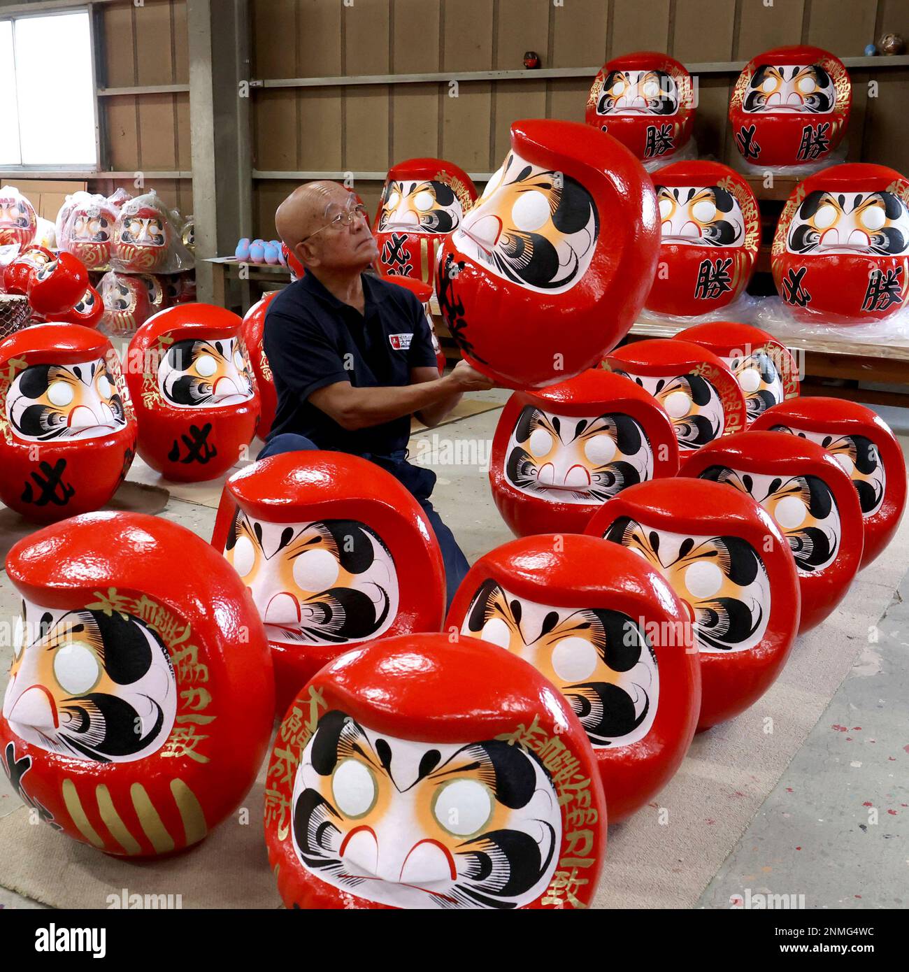 A craftsman is busy making Victory-themed Daruma dolls at a factory in ...