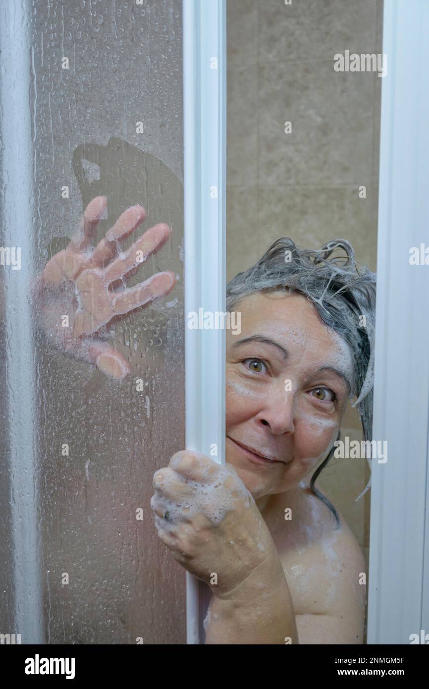 Woman in the shower covered with soap looking at the camera Stock Photo ...