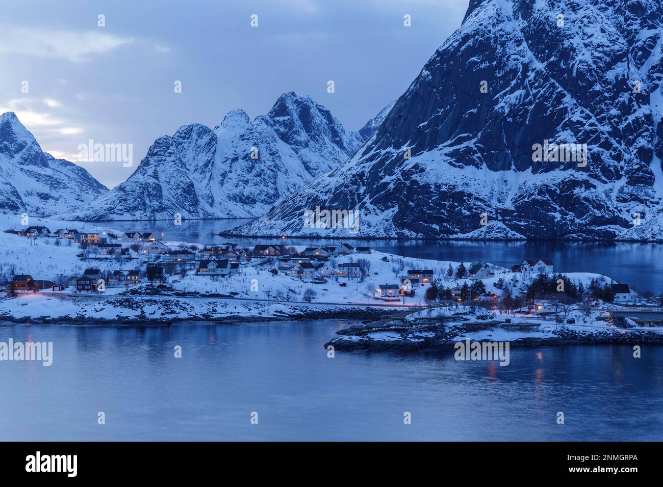 Fjord landscape in winter, twilight, snow-capped mountains behind ...