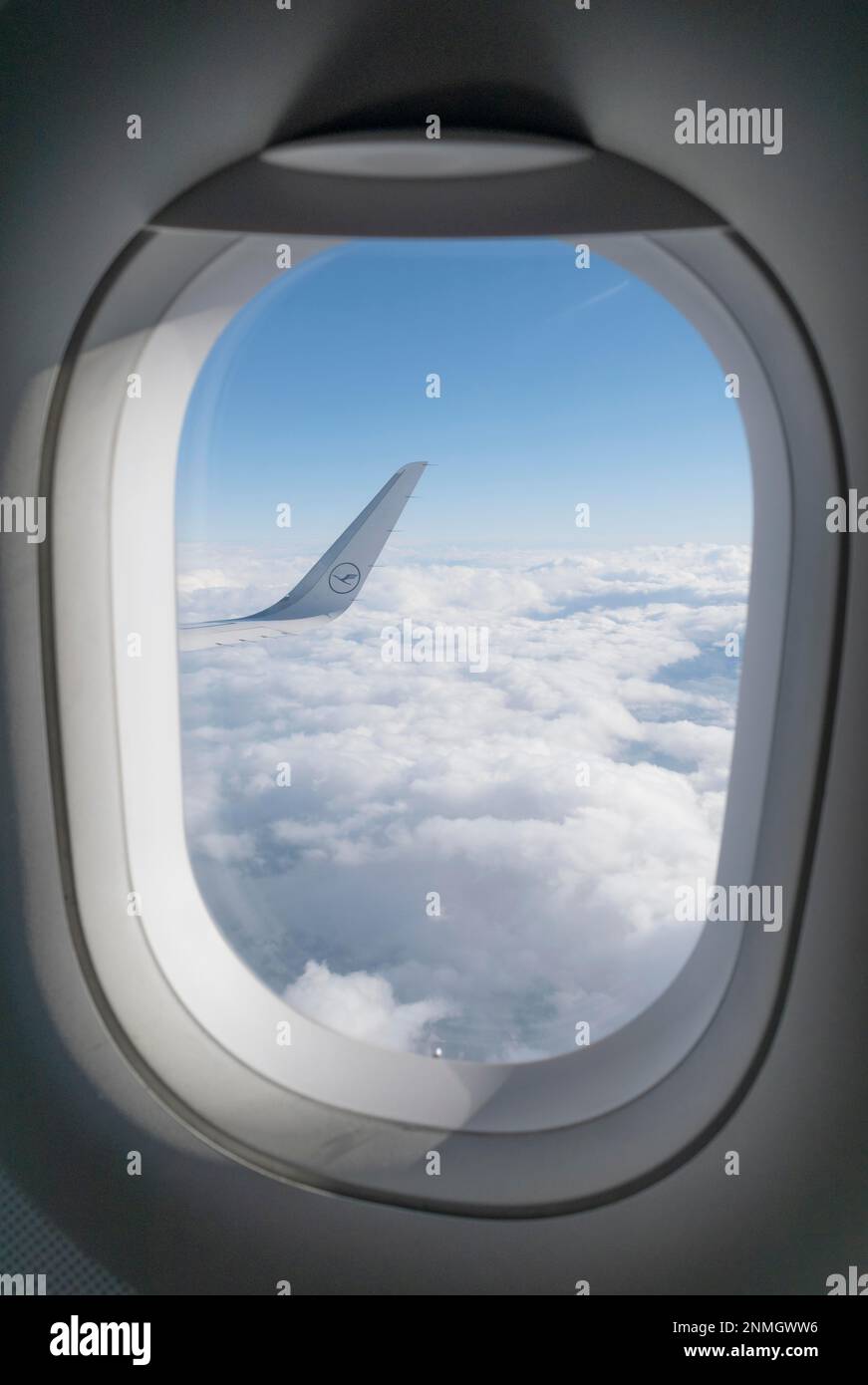 View from a window onto the wing of a Lufthansa aircraft over a sea of ...
