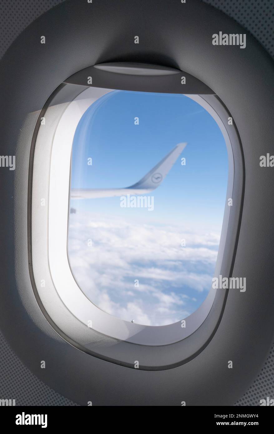 View from a window onto the wing of a Lufthansa aircraft over a sea of ...