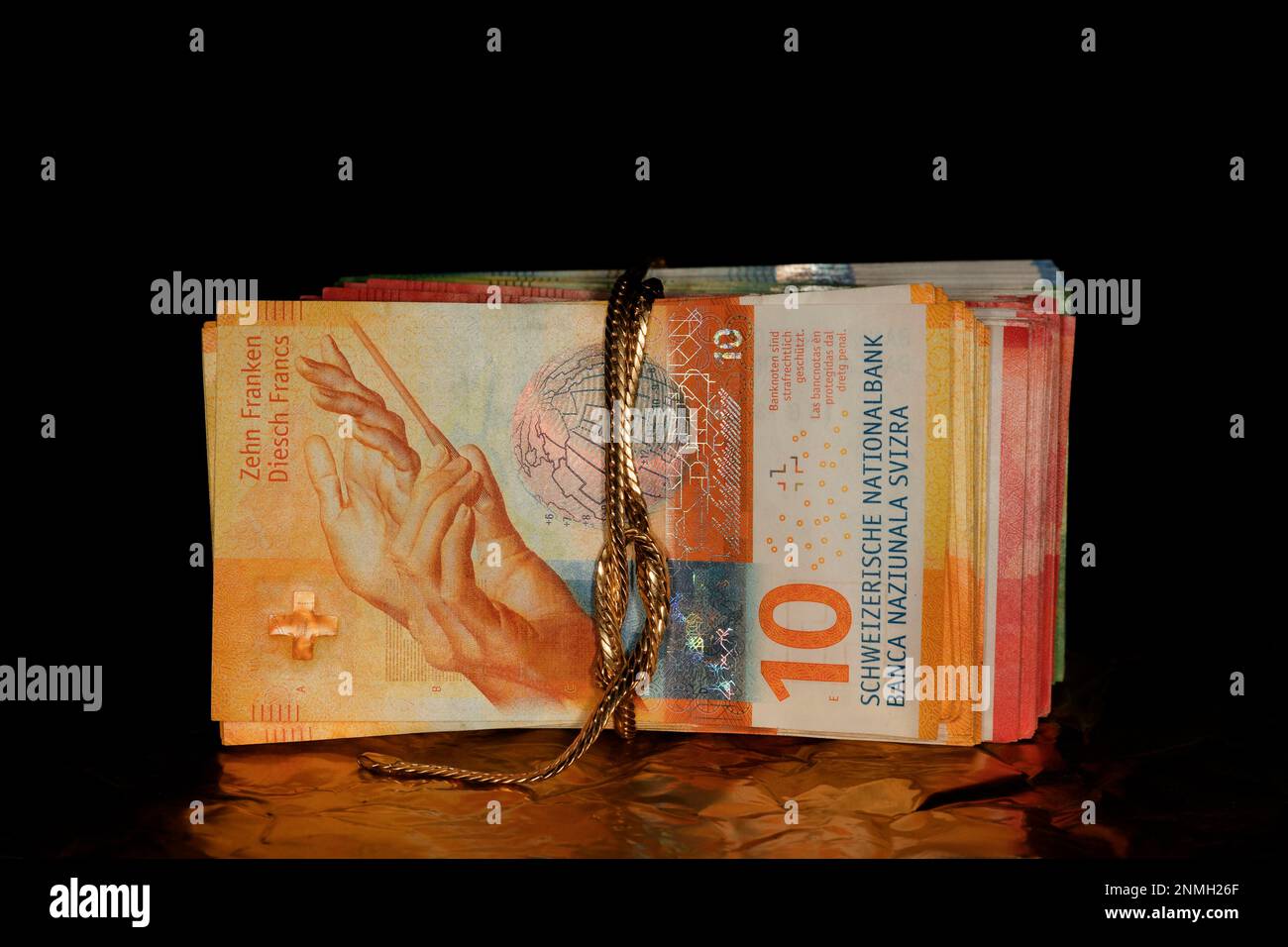 Symbol photo for black money in Switzerland, Swiss banknotes wrapped ...