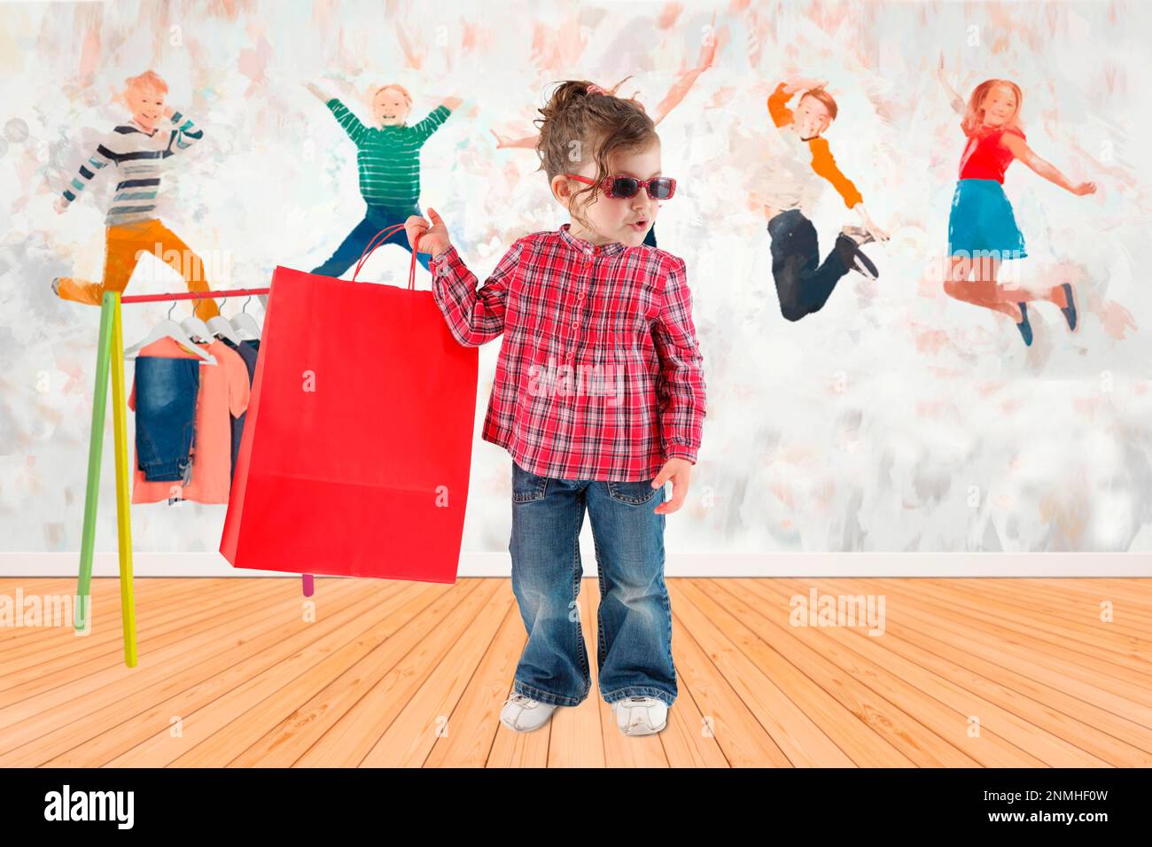 Child in the childrens room holding a shopping bag with new clothes in ...