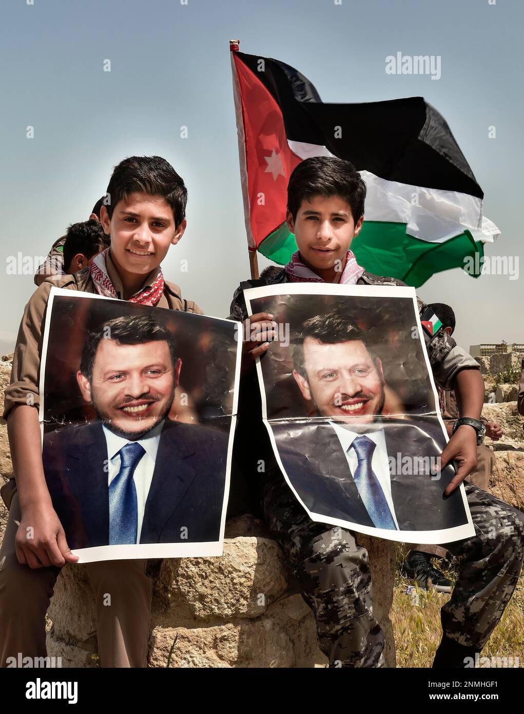 Two boys in scout uniform with portraits of Jordans King Abdullah II ...