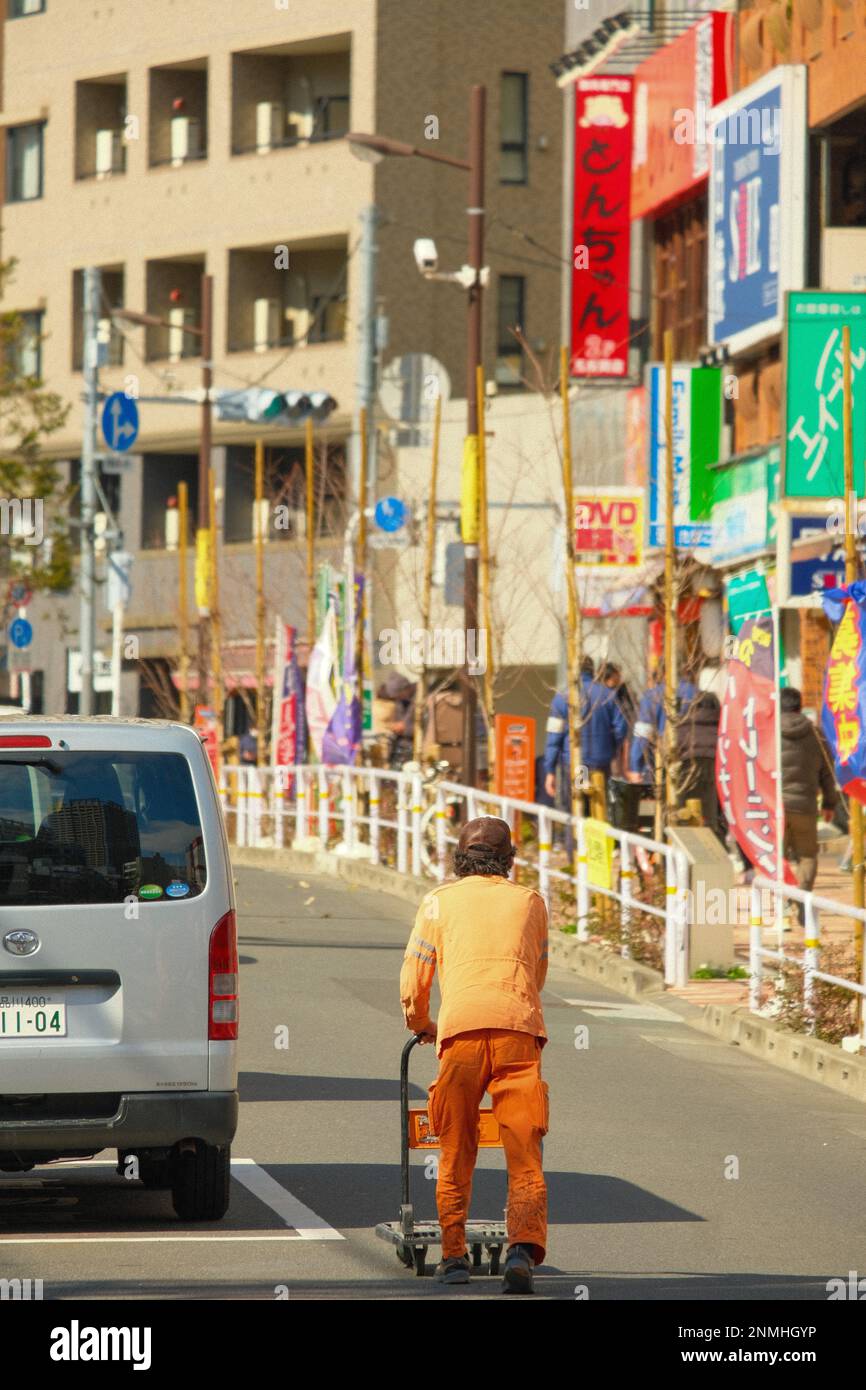 Man walking through Tokyo, Japan with trolley. High colour in a ...