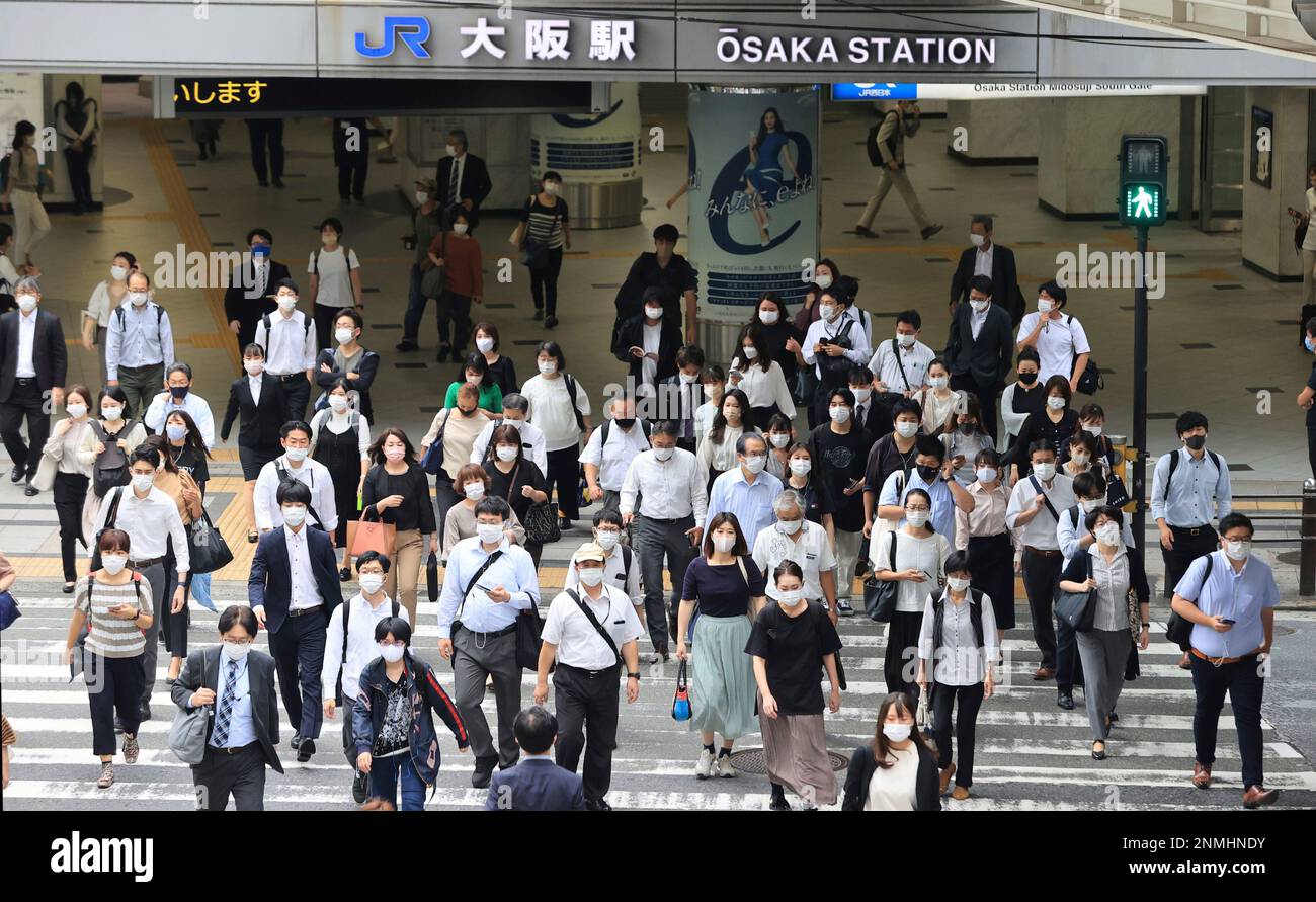 Commuters wearing masks walk near Osaka Station in Osaka on Oct. 1 ...