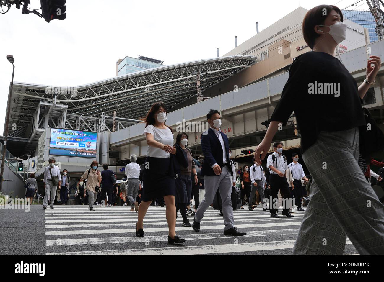 Commuters wearing masks walk near Osaka Station in Osaka on Oct. 1 ...