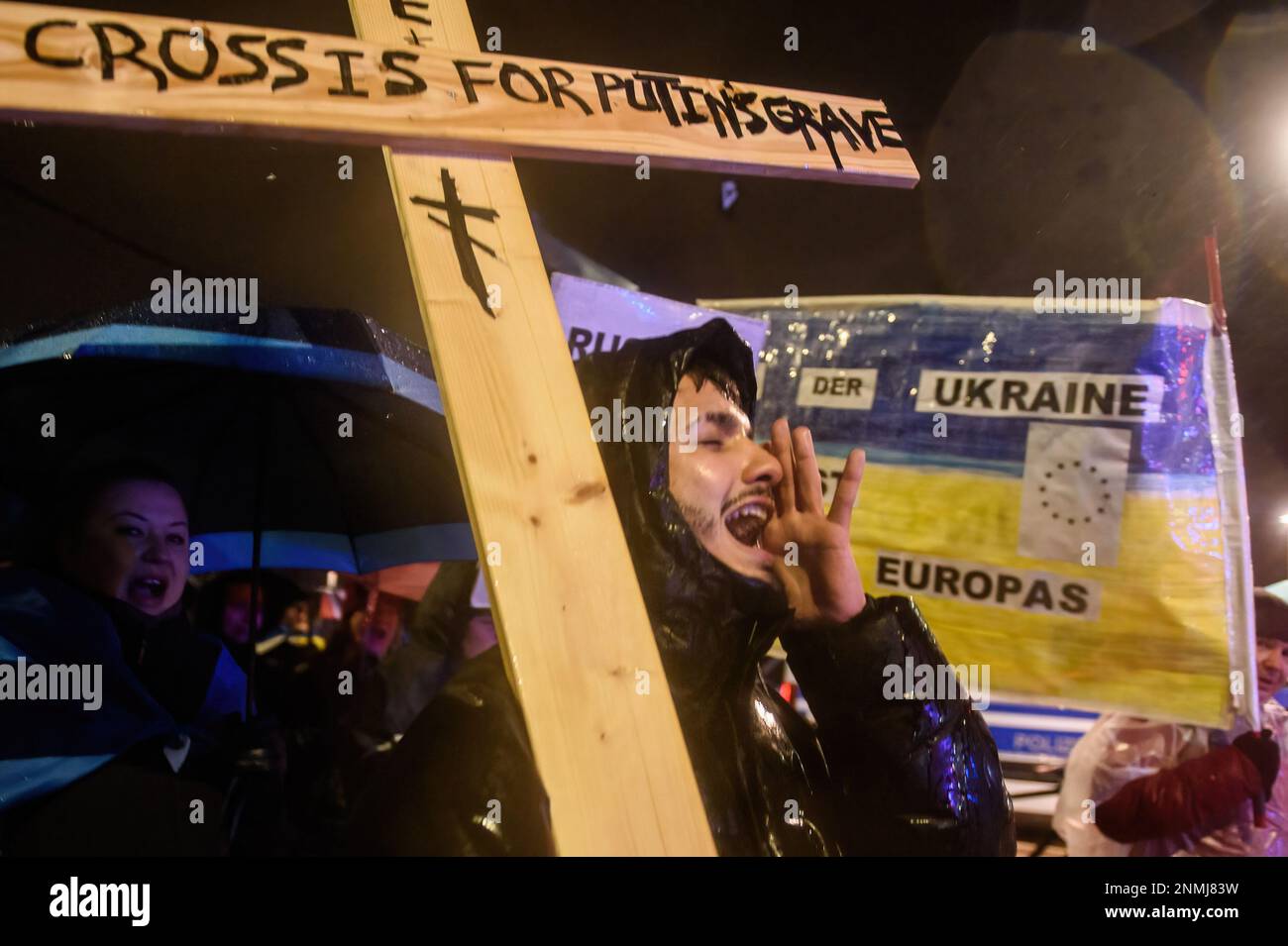 A protester shouts slogans as he holds a cross with the inscription ...