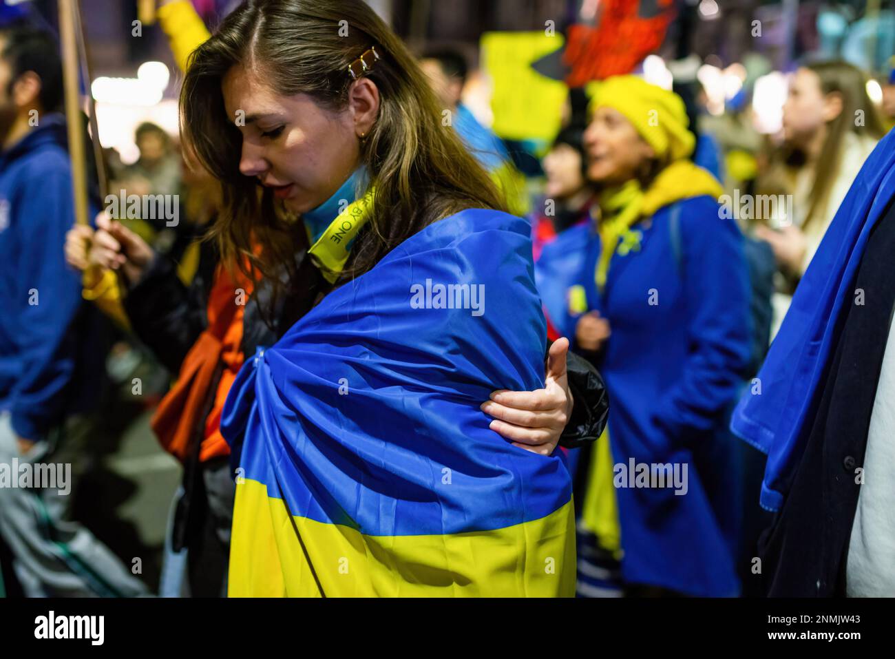 A demonstrator is seen draped with the Ukrainian flag during a march ...