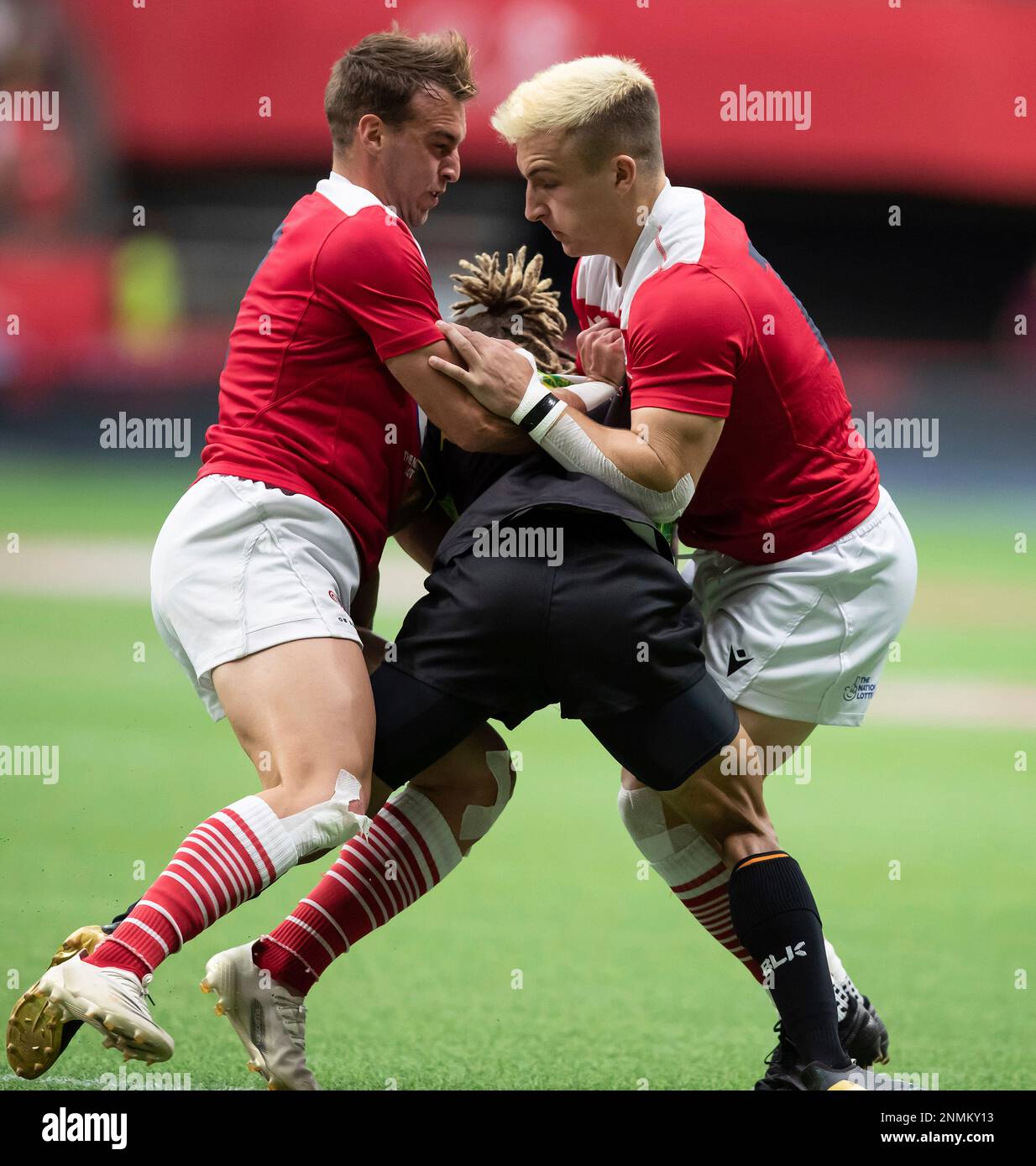 Britain's Tom Emery, left, and Ross McCann, right, tackle Jamaica's Ben ...