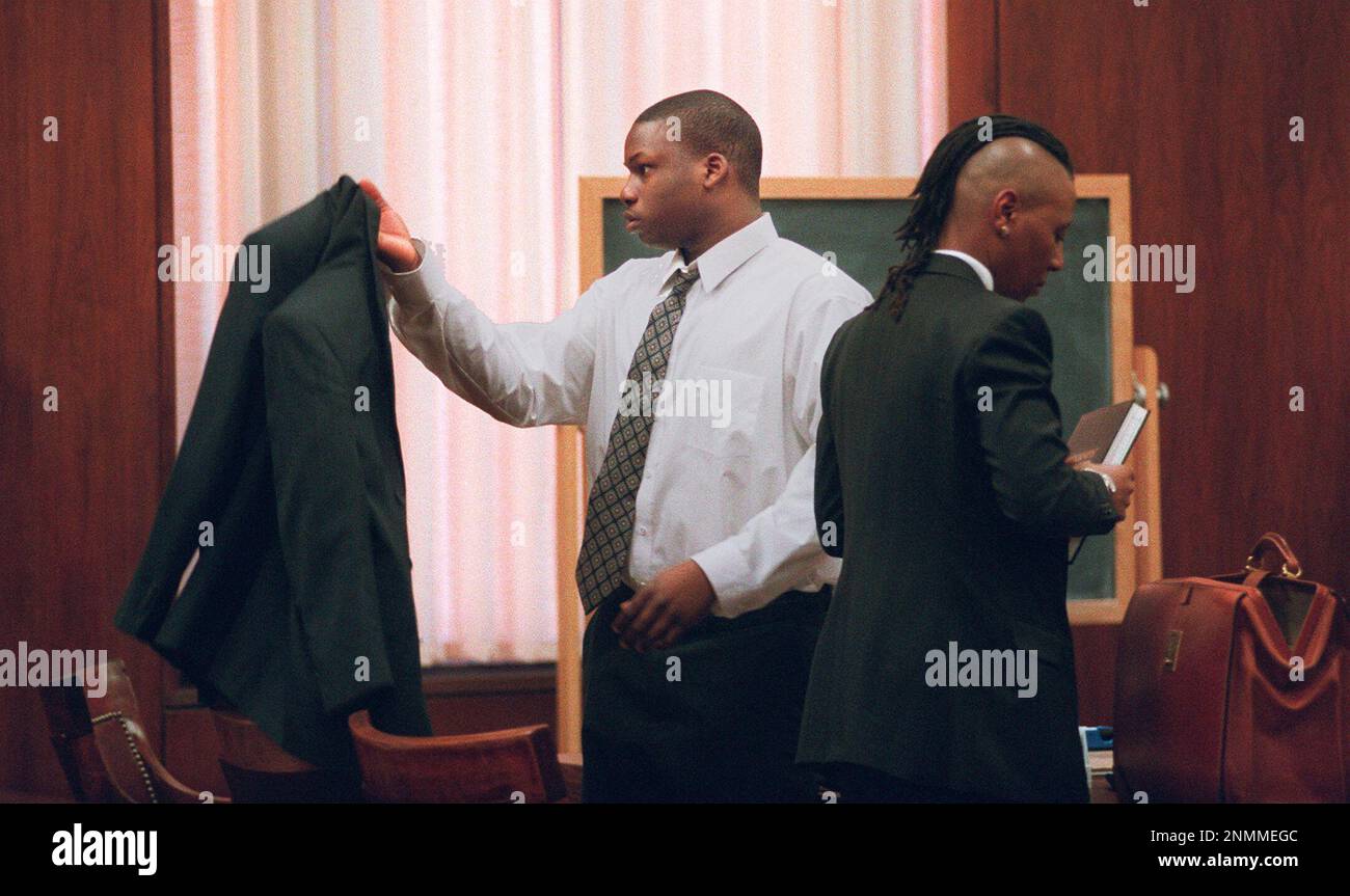 Murder defendant Raynard Cook, left, picks up his jacket as he leaves ...